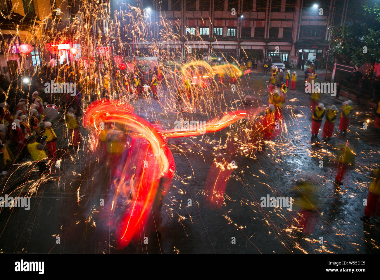Chinese entertainers perform a fire dragon dance in a shower of molten ...
