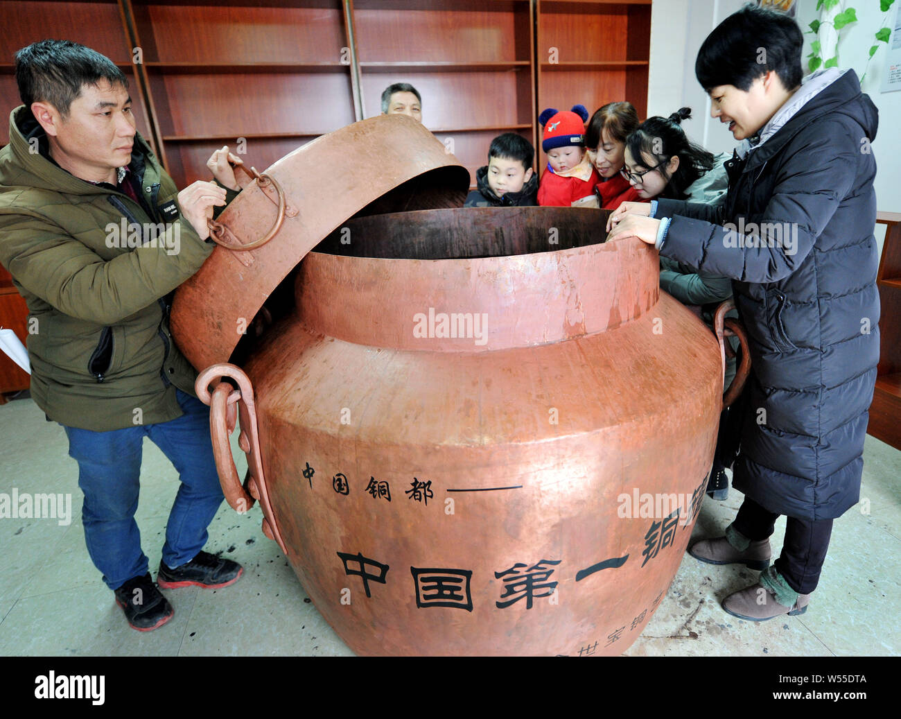 Visitors look at a huge copper pot able to boil 10,000 zongzi, a ...