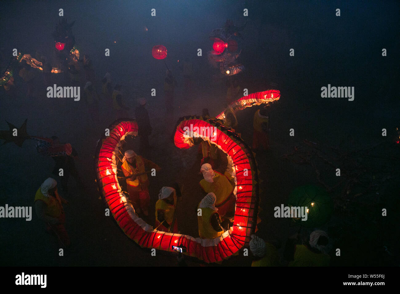 Chinese entertainers perform a fire dragon dance in a shower of molten ...