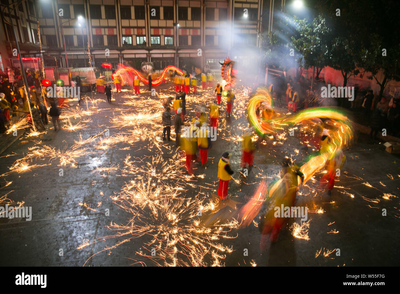 Chinese entertainers perform a fire dragon dance in a shower of molten ...