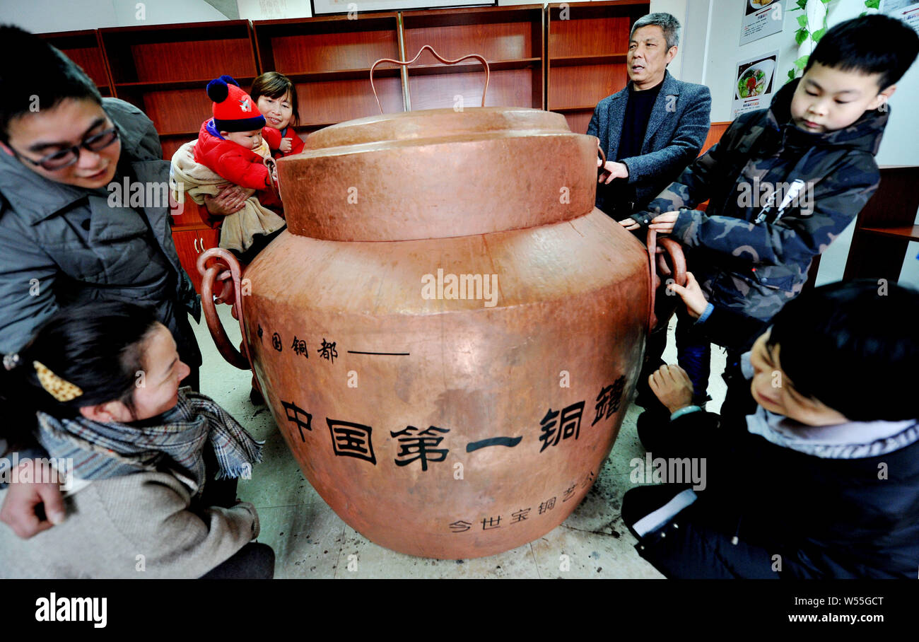 Visitors look at a huge copper pot able to boil 10,000 zongzi, a ...