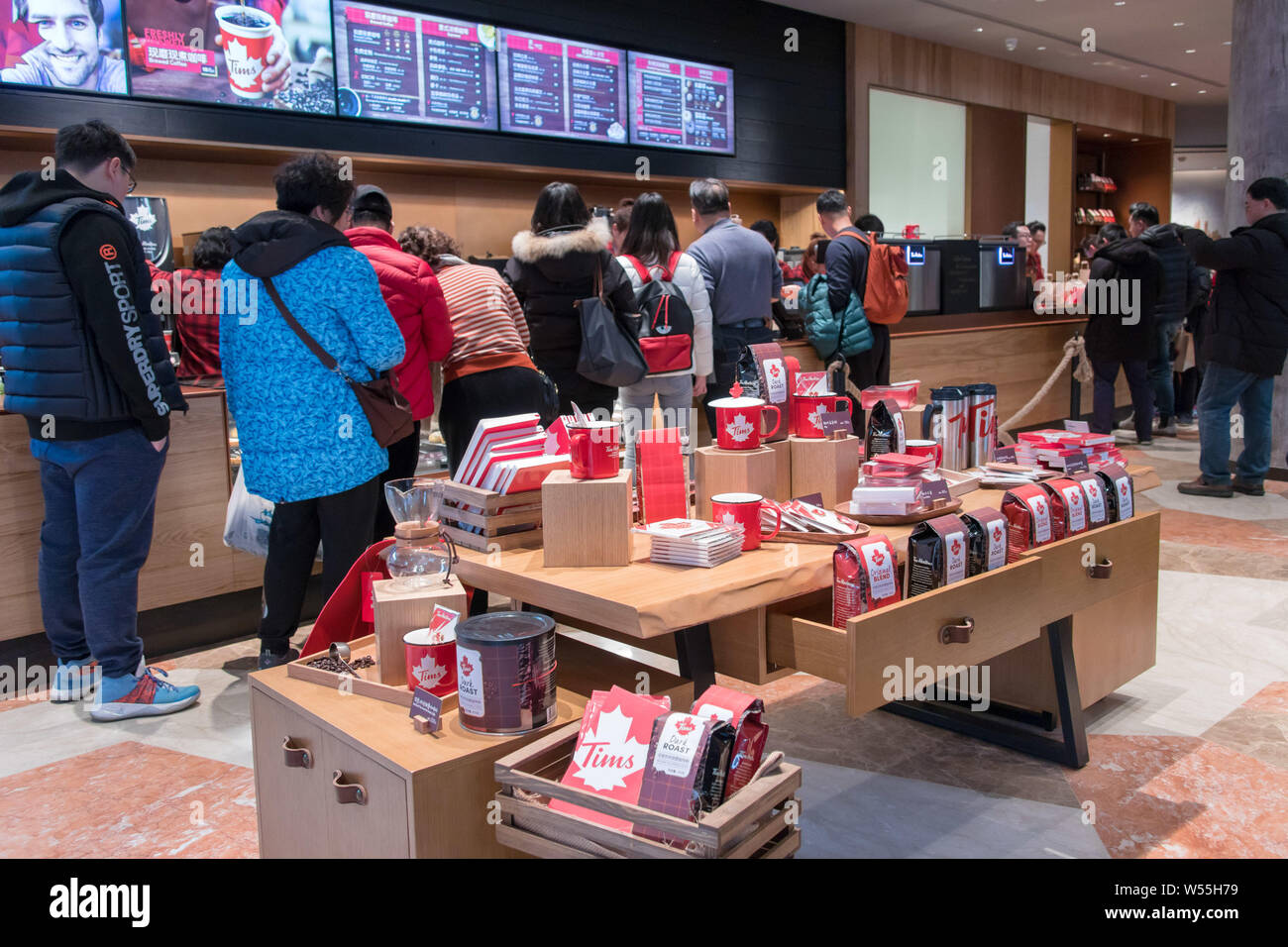 Consumers wait in line to buy coffee from Tim Hortons' first store in ...