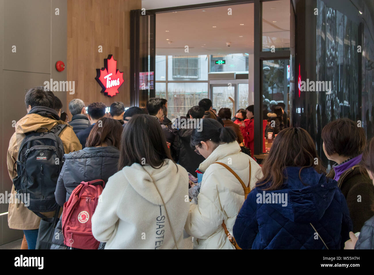 Consumers wait in line to buy coffee from Tim Hortons' first store in ...