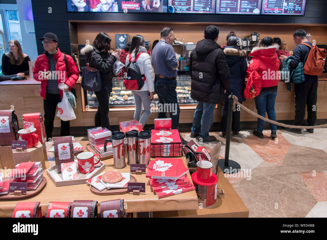 Consumers wait in line to buy coffee from Tim Hortons' first store in ...