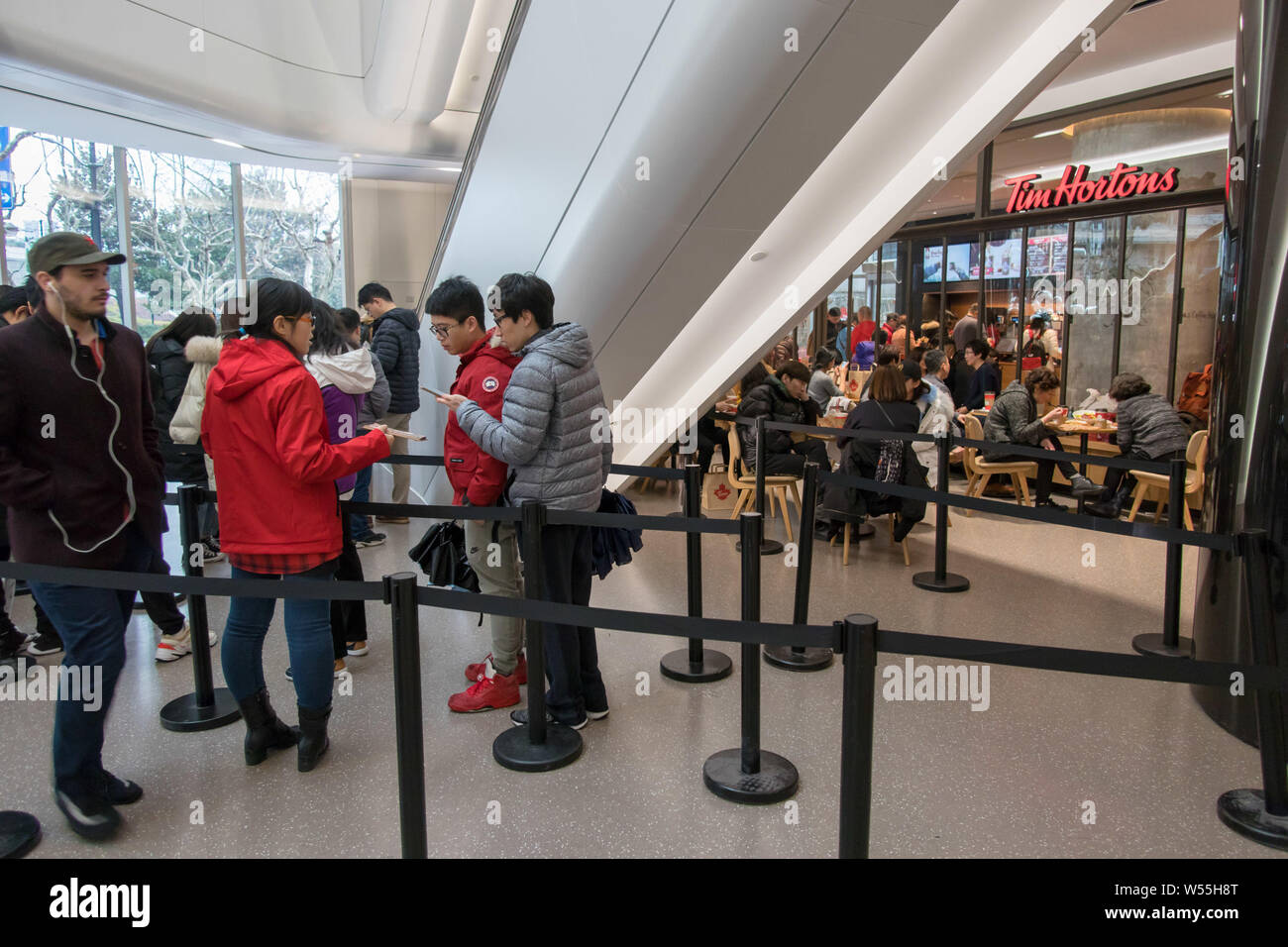 Consumers wait in line to buy coffee from Tim Hortons' first store in ...