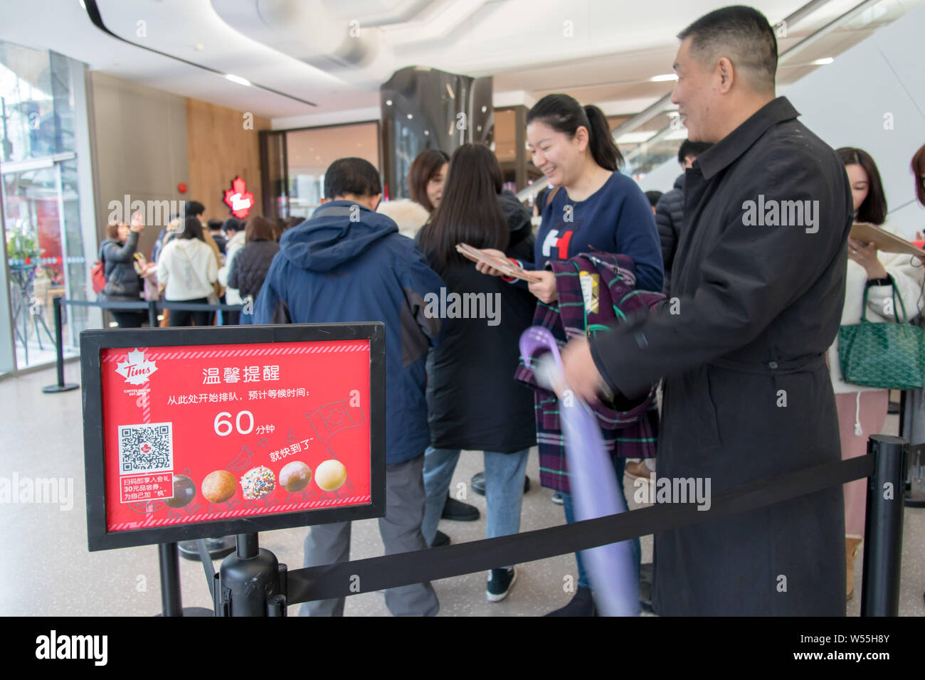 Consumers wait in line to buy coffee from Tim Hortons' first store in ...