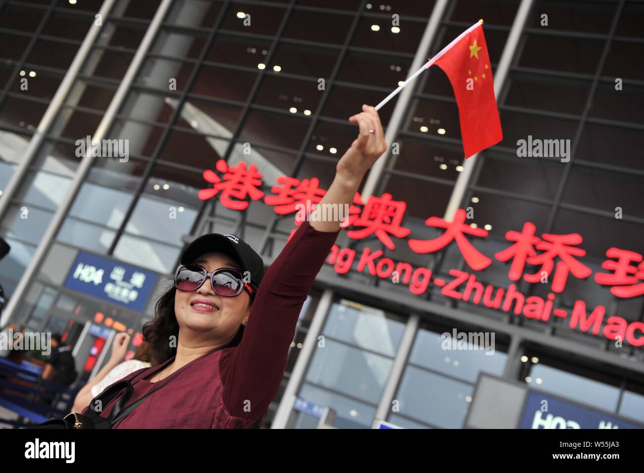 --FILE--A Chinese tourist waving a Chinese national flag poses in front ...