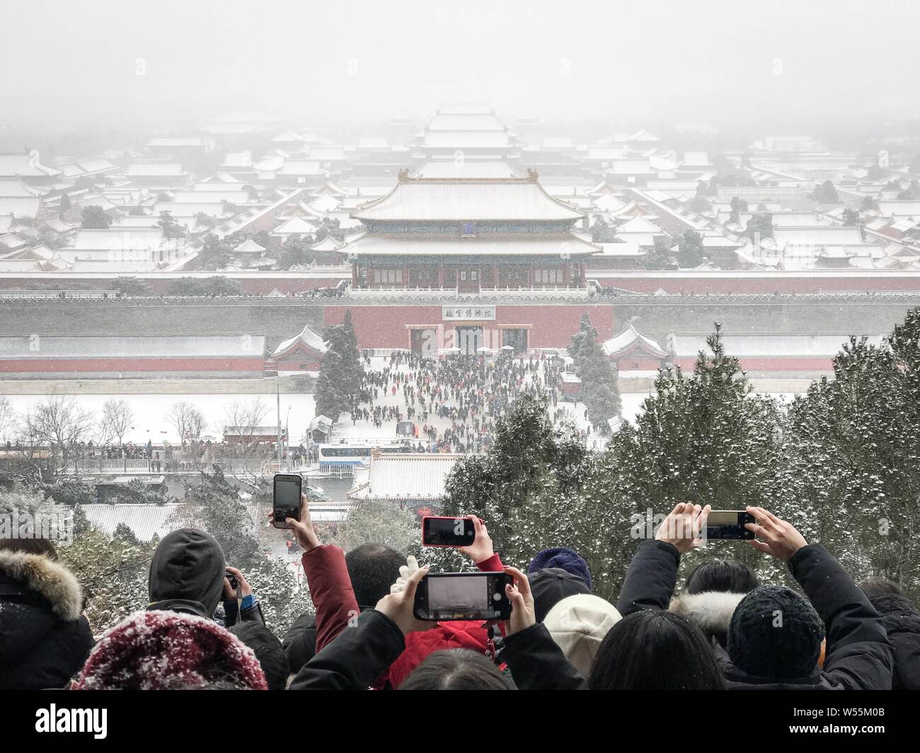 Tourists take photos of the Palace Museum, also known as the Forbidden ...