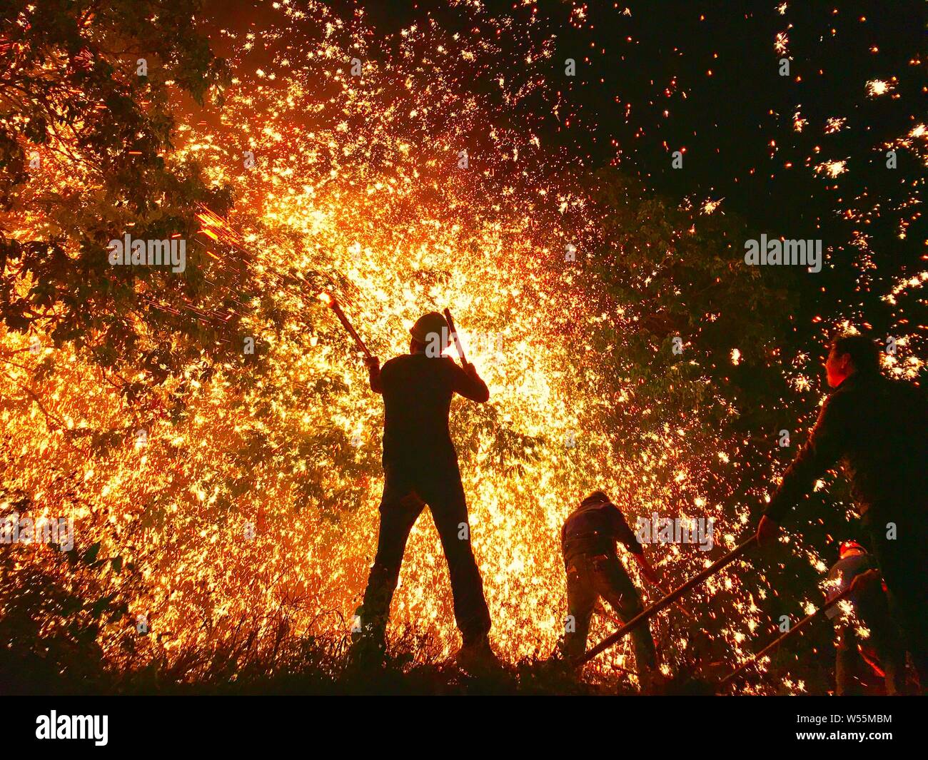 Chinese artists spray molten iron water to create sparks into the sky ...