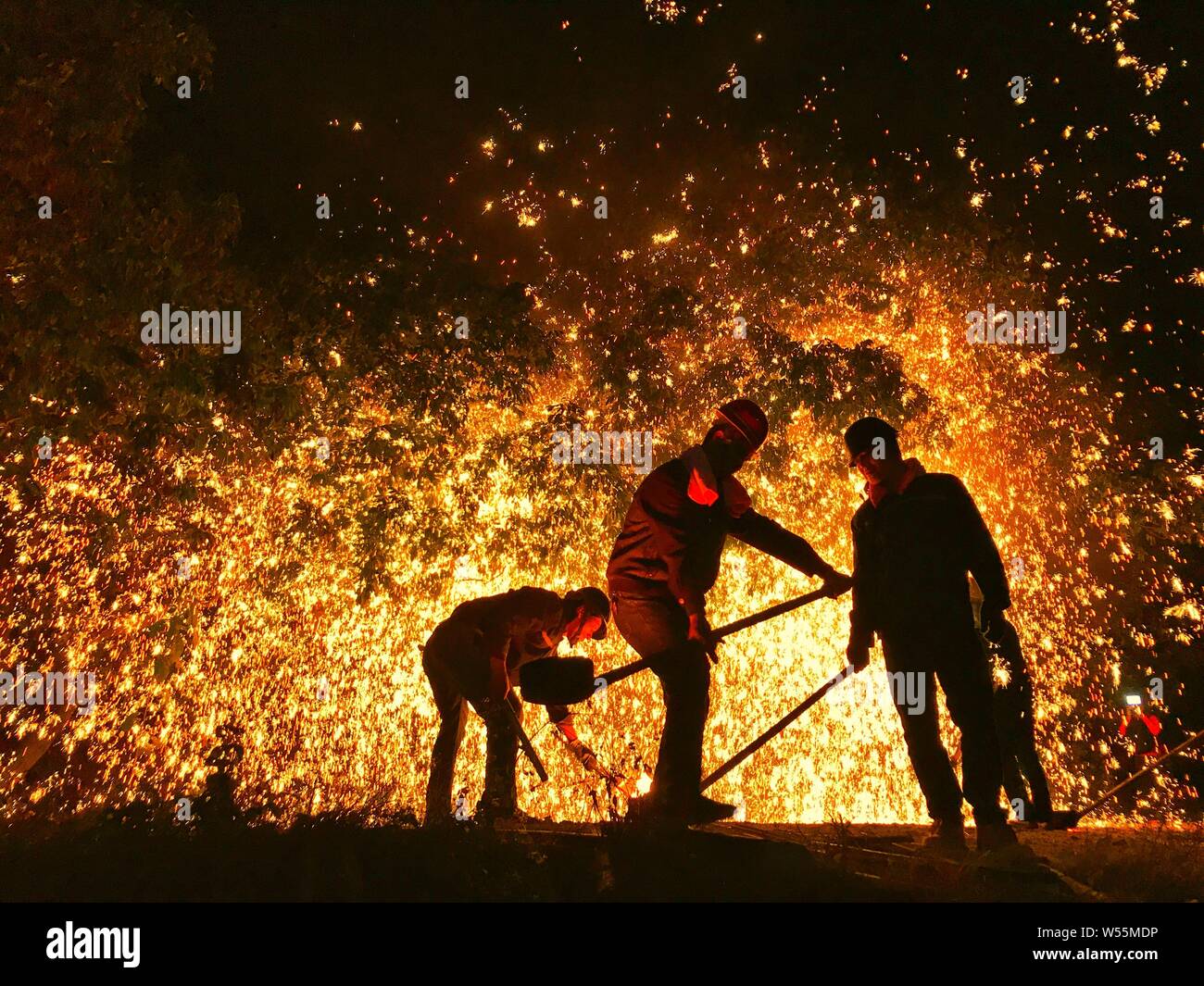 Chinese artists spray molten iron water to create sparks into the sky ...
