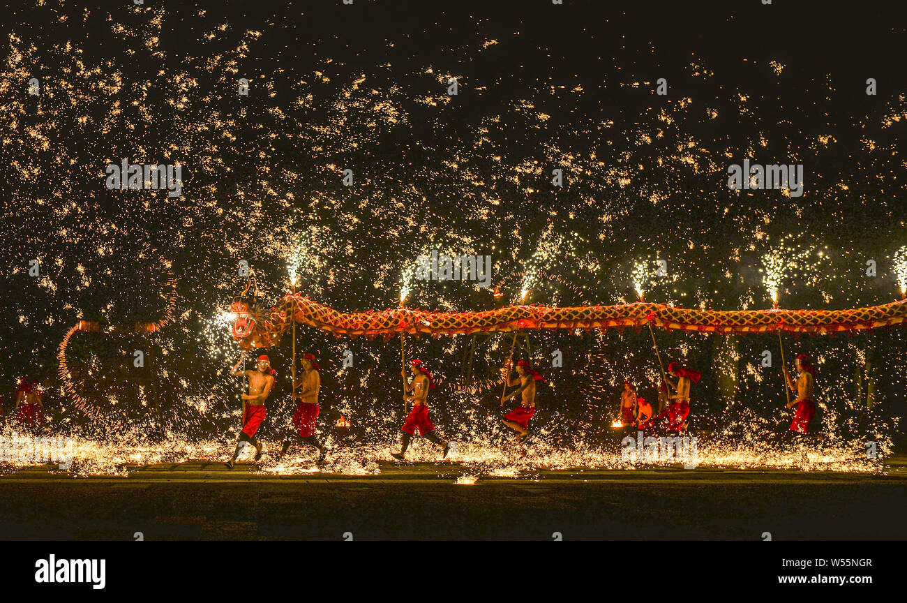 Chinese entertainers perform a fire dragon dance in a shower of molten ...