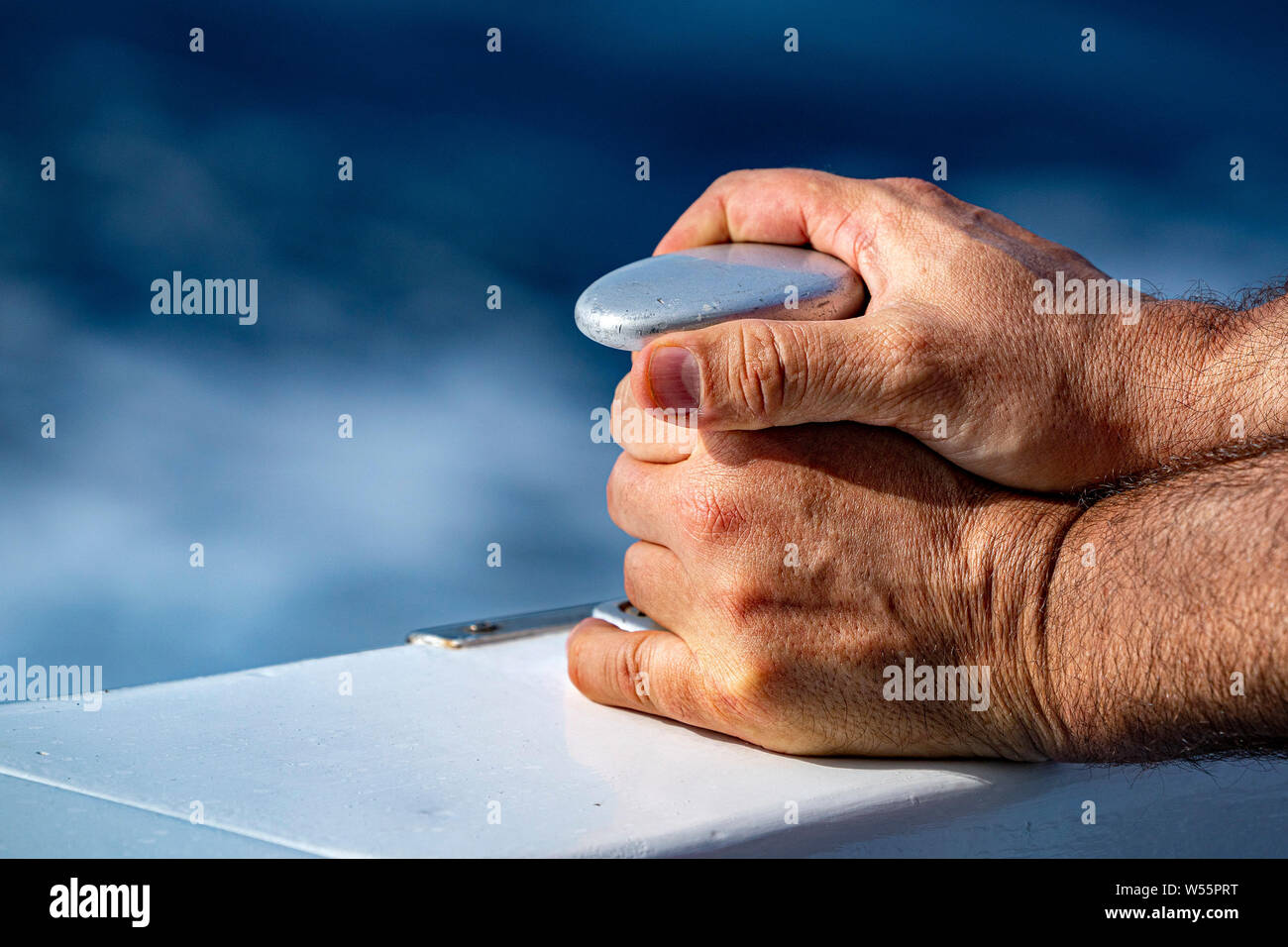 hands of sailor detail on ong boat bollard Stock Photo - Alamy