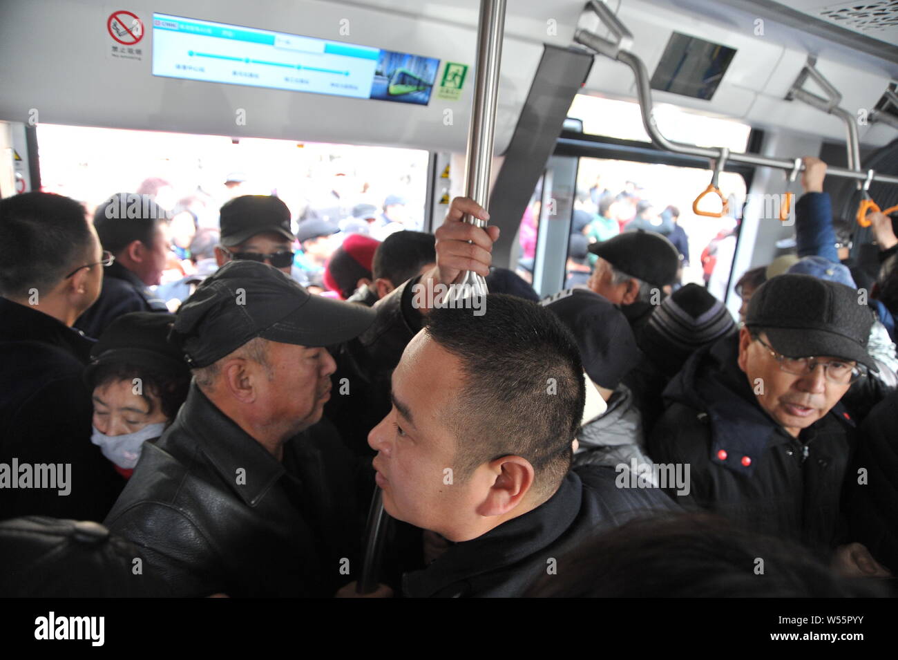 Local residents crowd a newly-developed smart electric train on a road ...