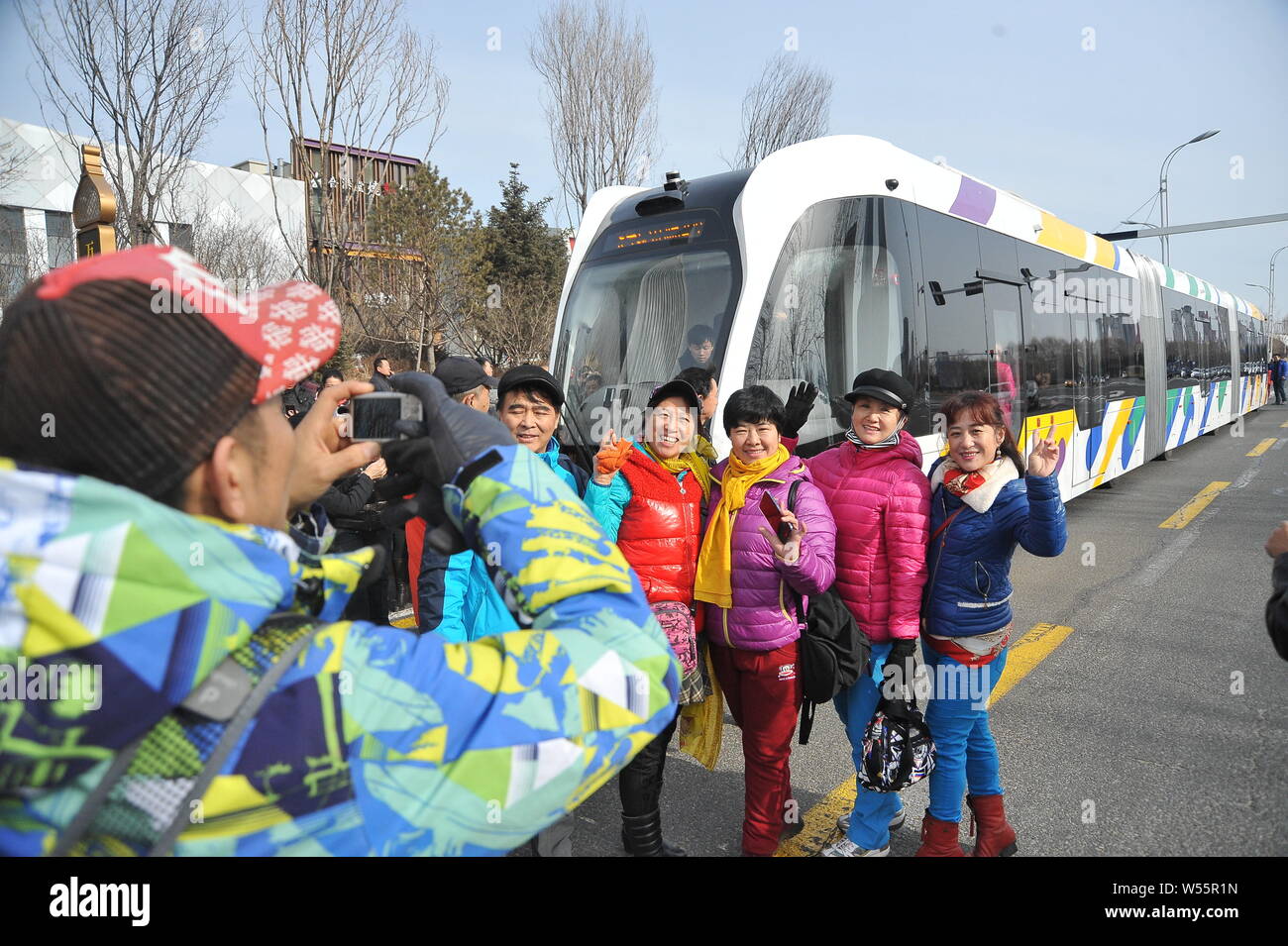 Local residents crowd a newly-developed smart electric train on a road ...