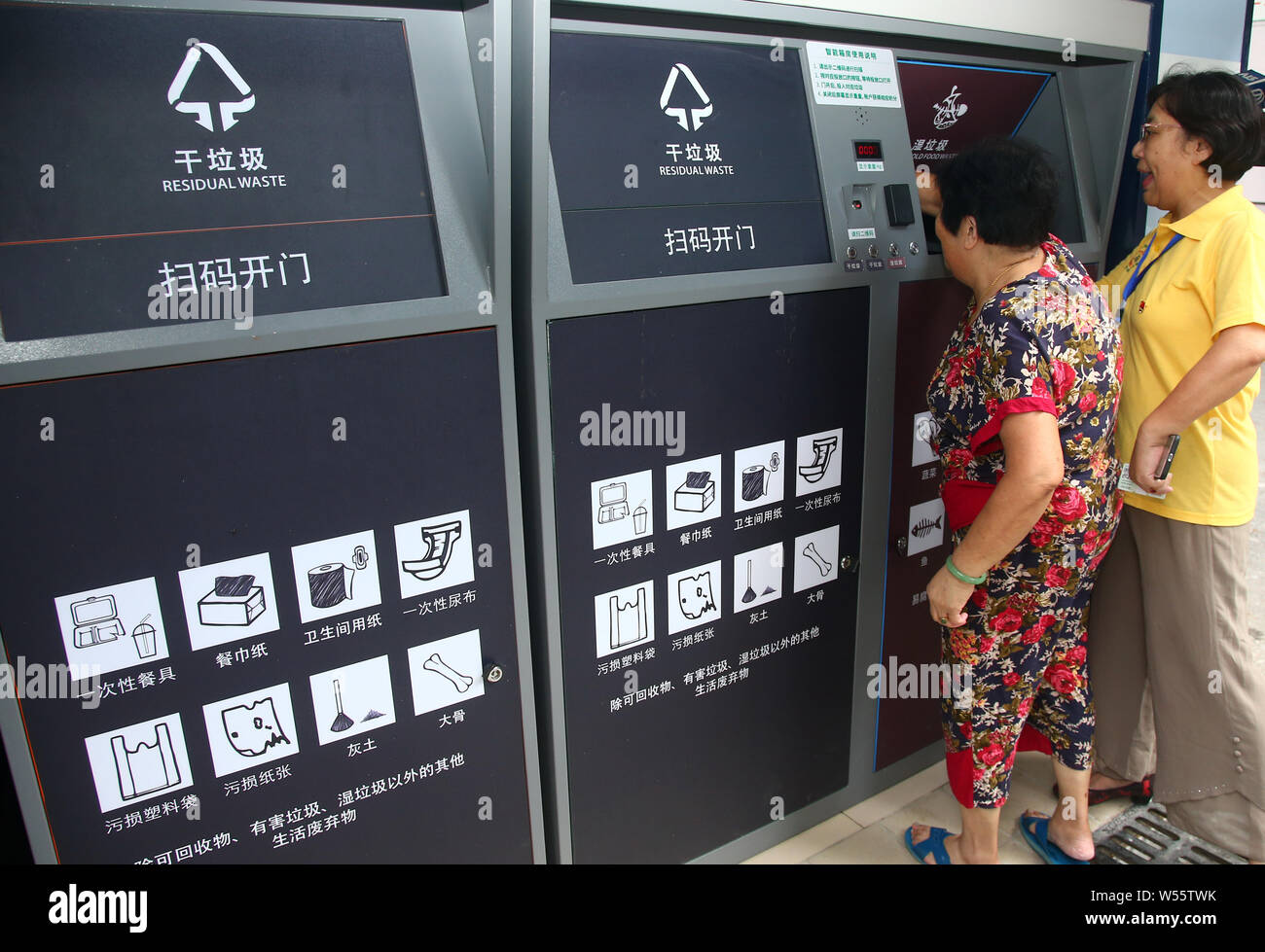 --FILE--Local residents sort garbage and recyclables into the ...