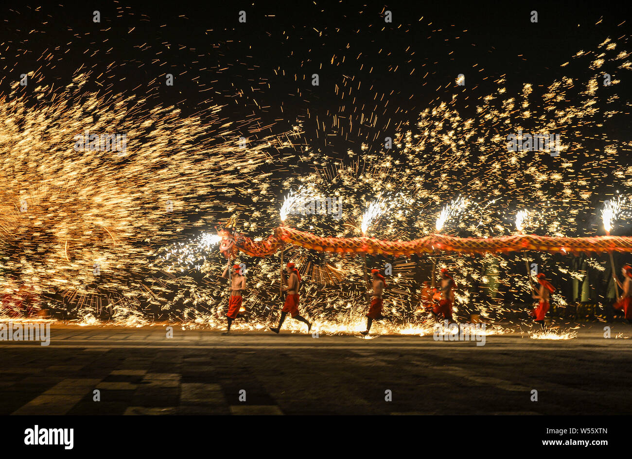Chinese entertainers perform a fire dragon dance in a shower of molten ...