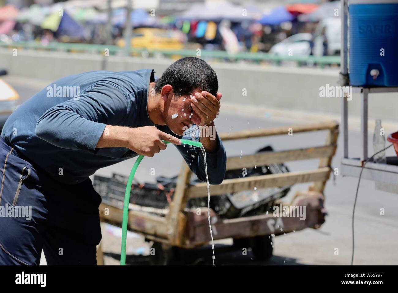 Baghdad, Iraq. 26th July, 2019. A man washes his face to cool off amid ...