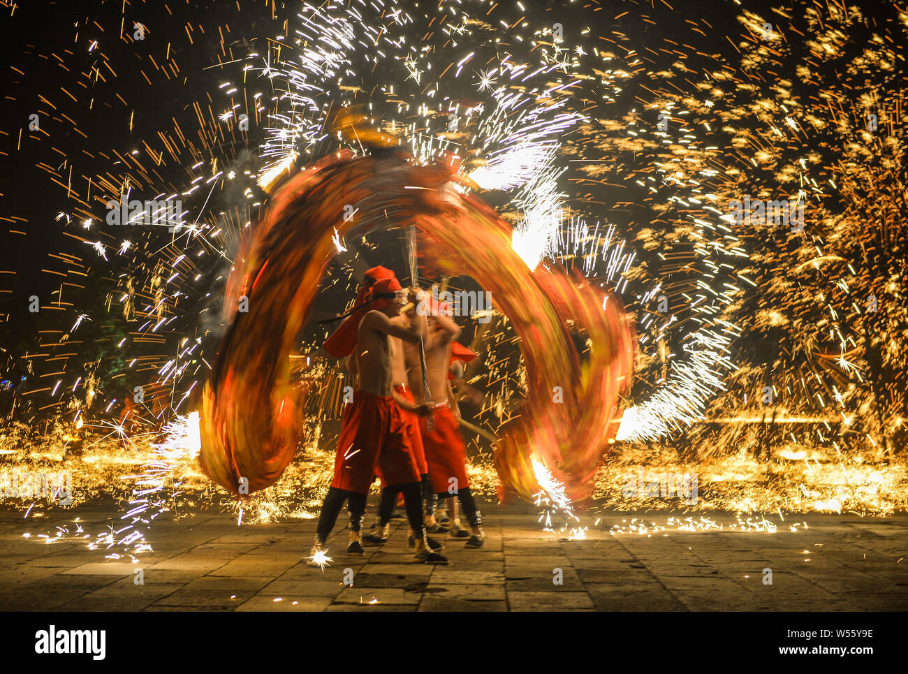 Chinese entertainers perform a fire dragon dance in a shower of molten ...