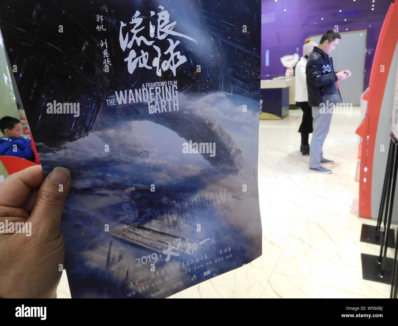 --FILE--A Chinese filmgoer shows a poster of the movie "The Wandering ...