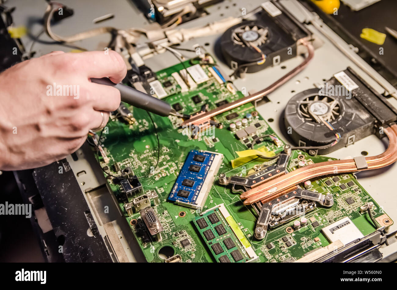Technical support worker unspins the cover of the computer of the ...