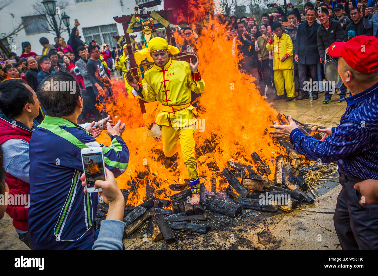 Chinese villagers walk across the fire during a fire-jumping activity ...