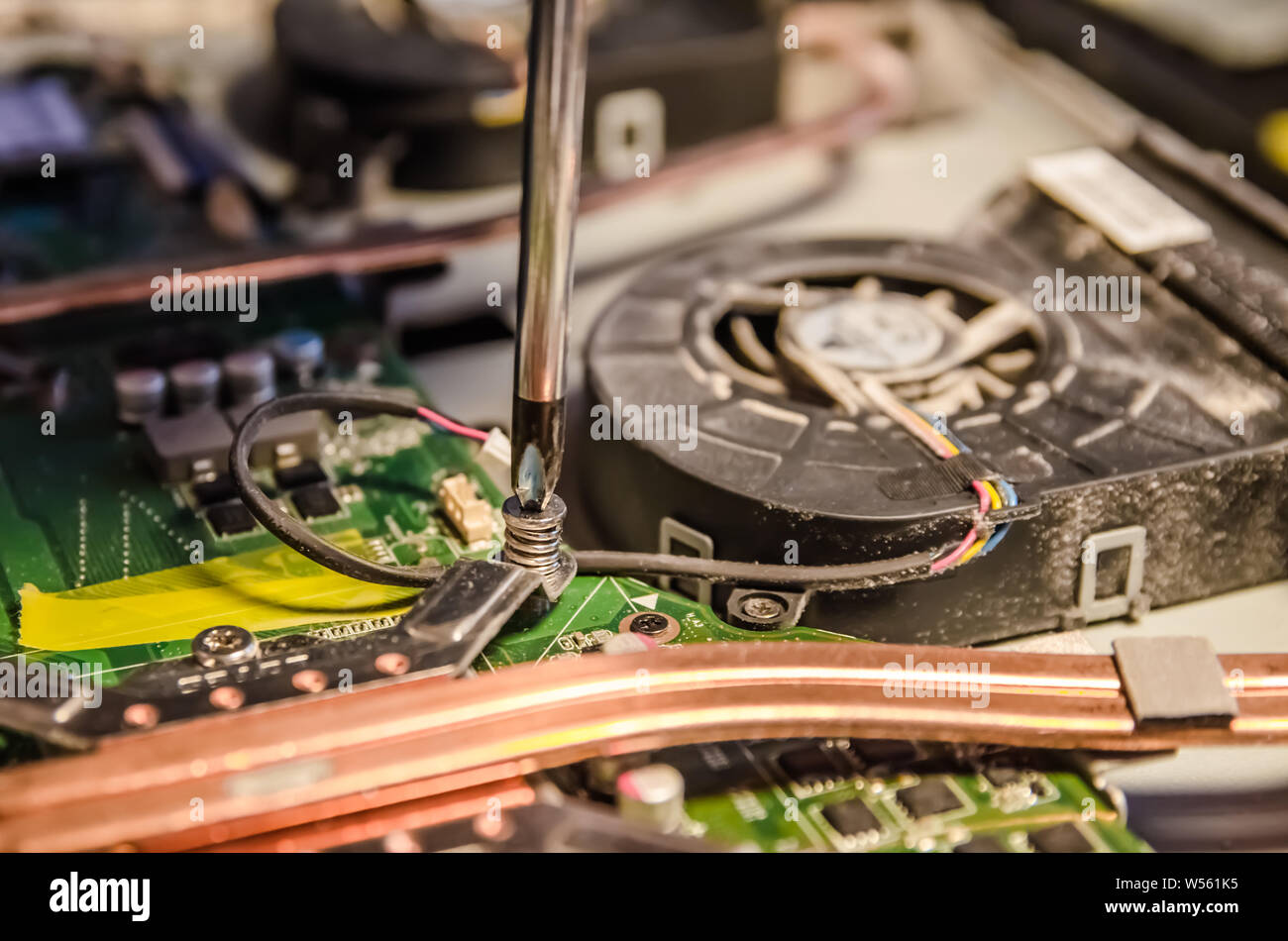 Technical support worker unspins the cover of the computer of the ...
