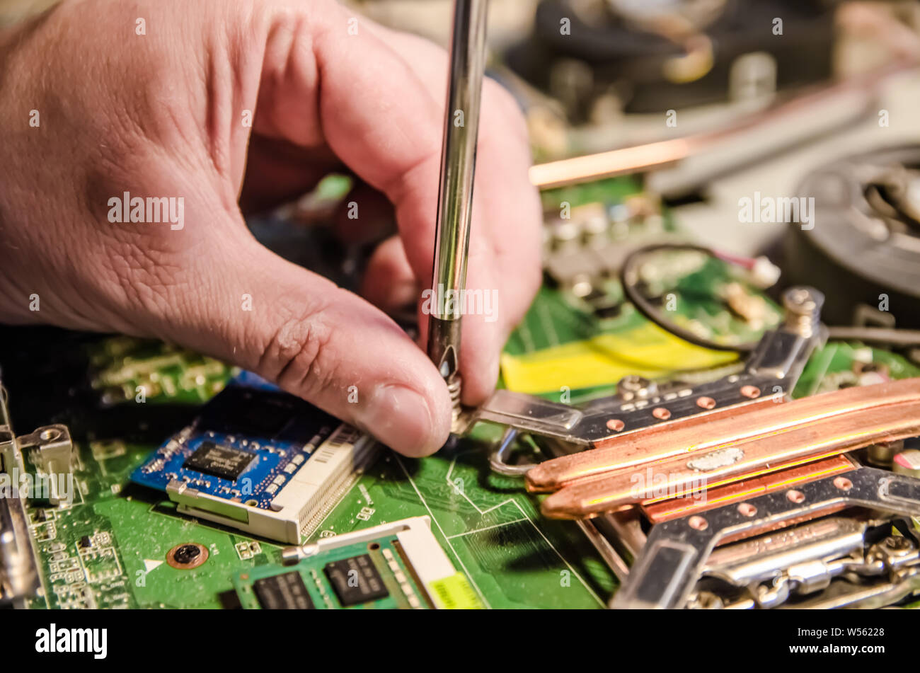 Technical support worker unspins the cover of the computer of the ...