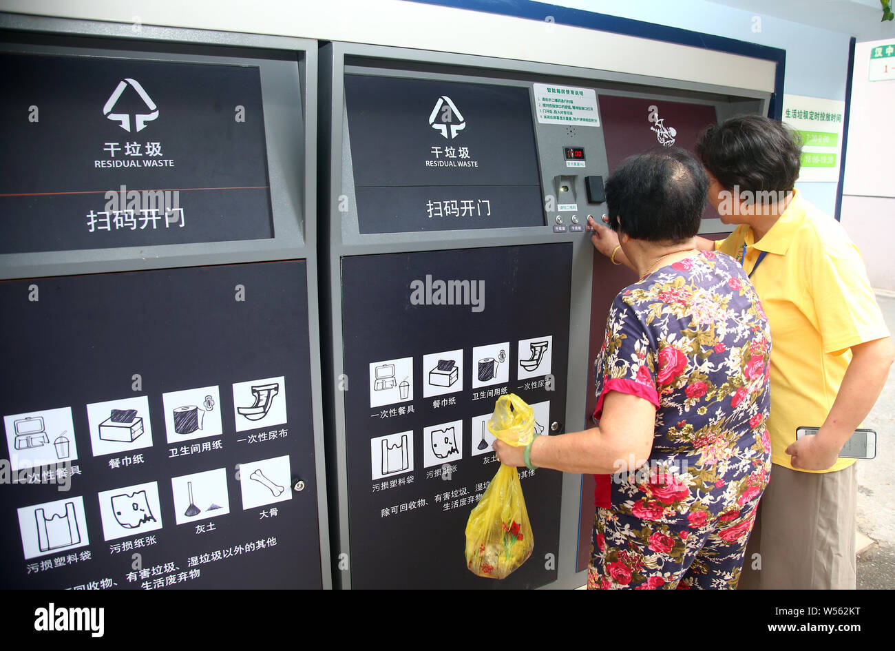 --FILE--Local residents sort garbage and recyclables into the ...