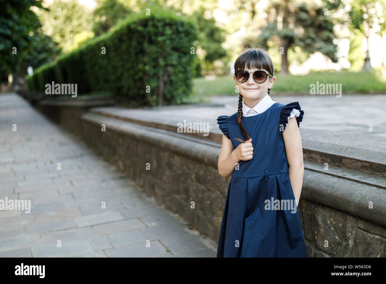 A cute schoolgirl girl is having fun on the street in the park Stock ...