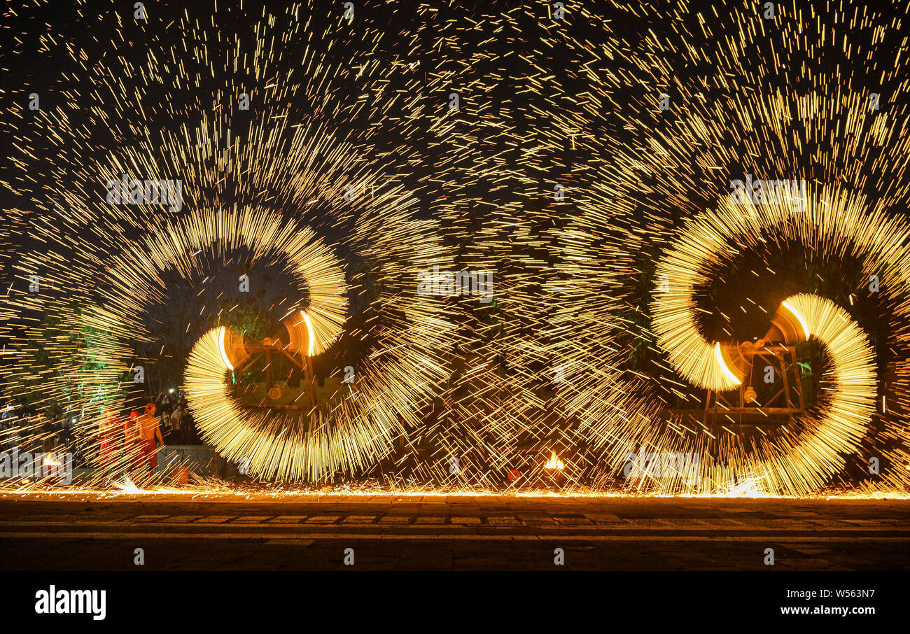 Chinese entertainers perform a fire dragon dance in a shower of molten ...
