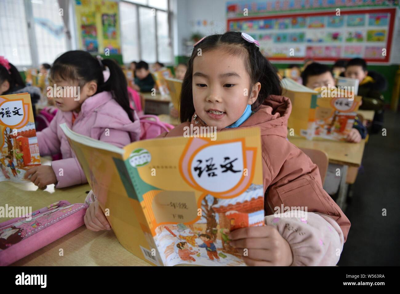 --FILE--Pupils read the new Mandarin Chinese textbooks at a primary ...