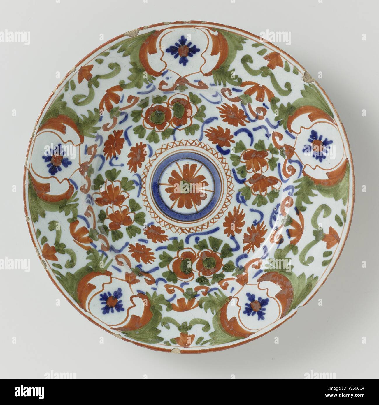 Plate of multicolored painted faience with flower decoration, Round ...
