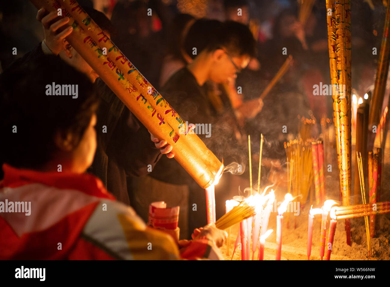 Chinese worshippers burn incense sticks to pray for good luck before ...
