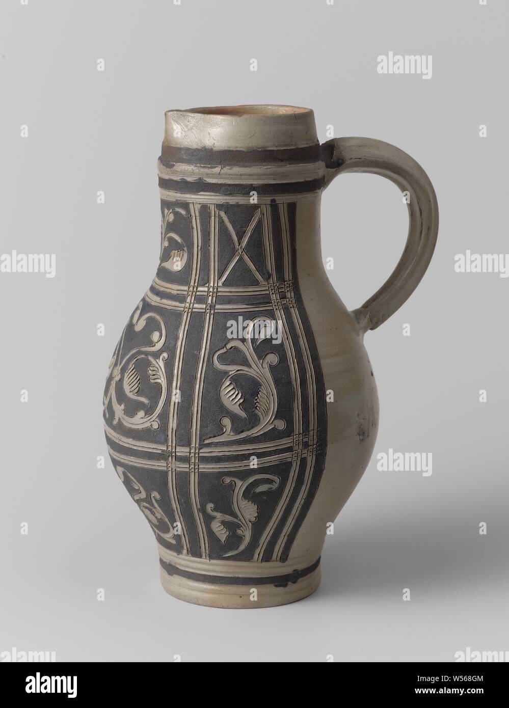 Jug with foliate scrolls in panels, Stoneware jug with a pear-shaped body and wide neck with a ...