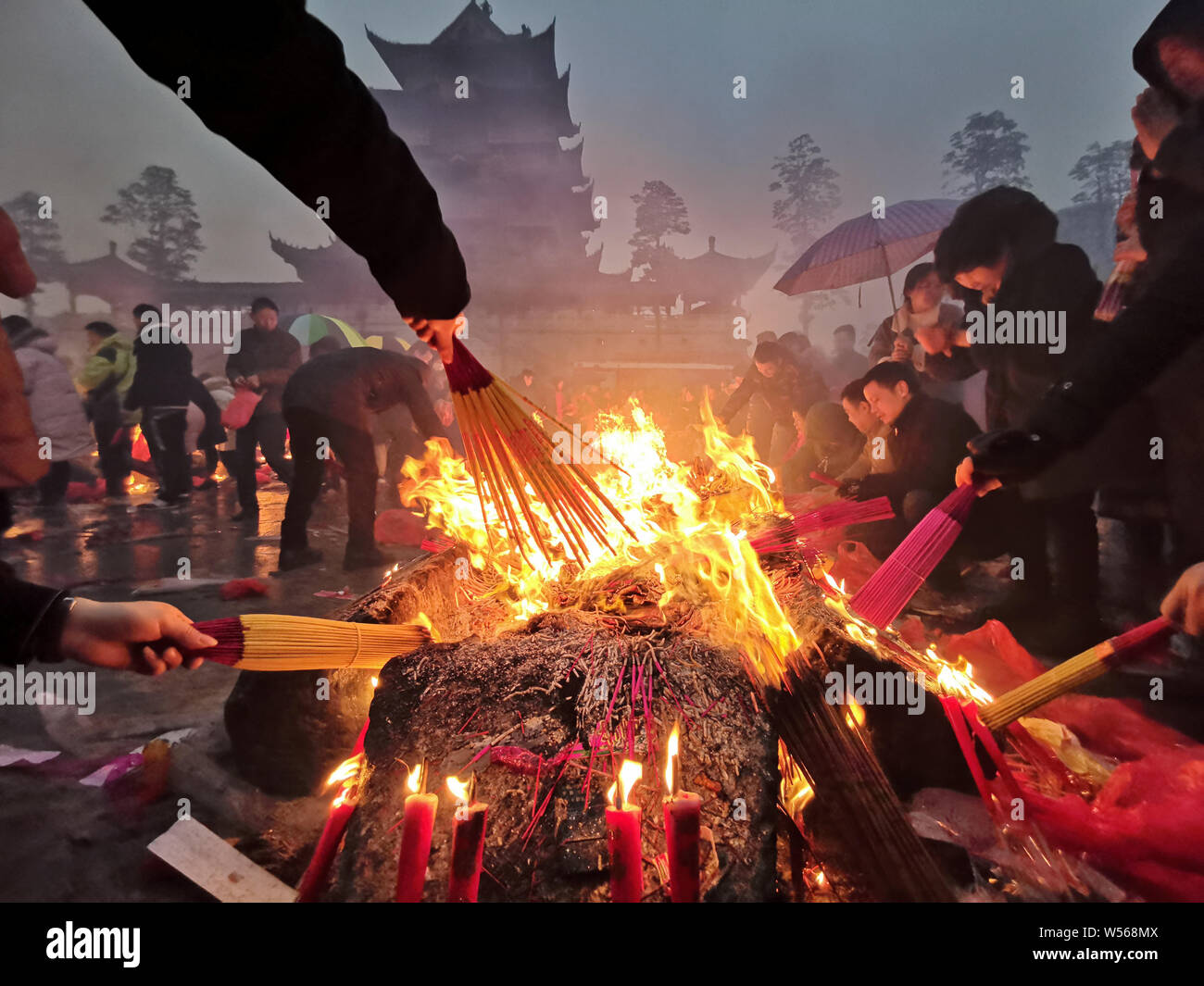 Chinese worshippers burn incense sticks to pray for wealth and ...