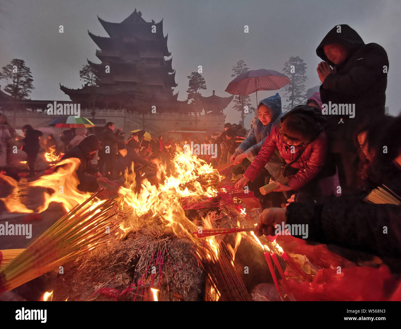 Chinese worshippers burn incense sticks to pray for wealth and ...