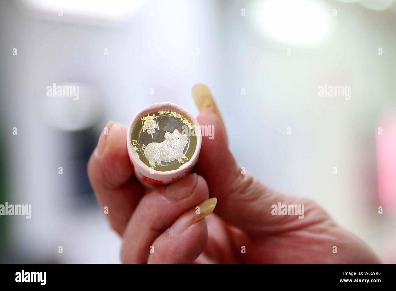 A local Chinese resident shows commemorative coins for the 70th ...