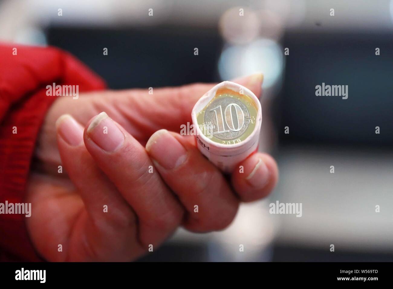 A local Chinese resident shows commemorative coins for the 70th ...
