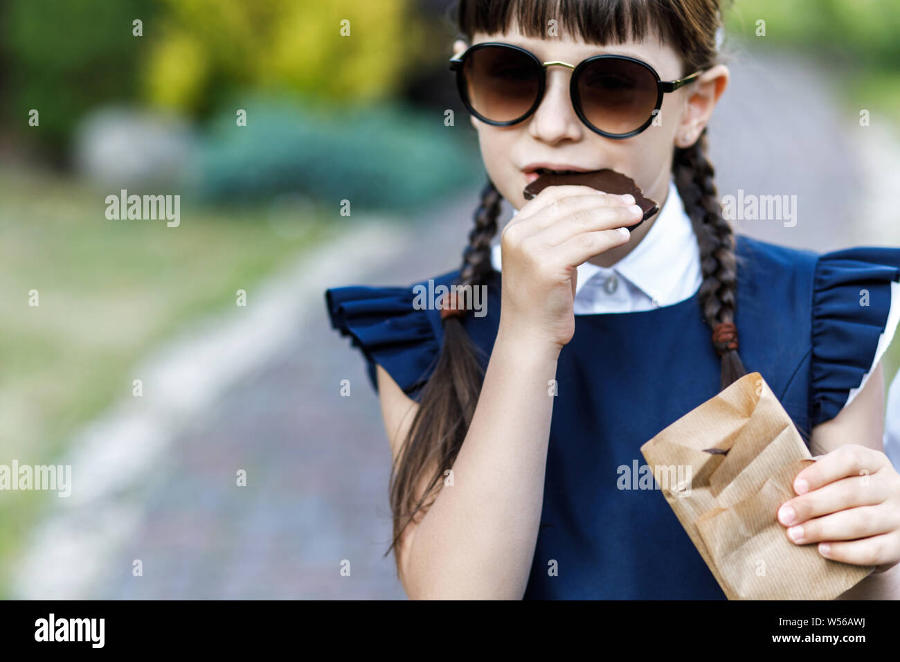 Cute girl, school years dressed in school uniform with pleasure eating ...