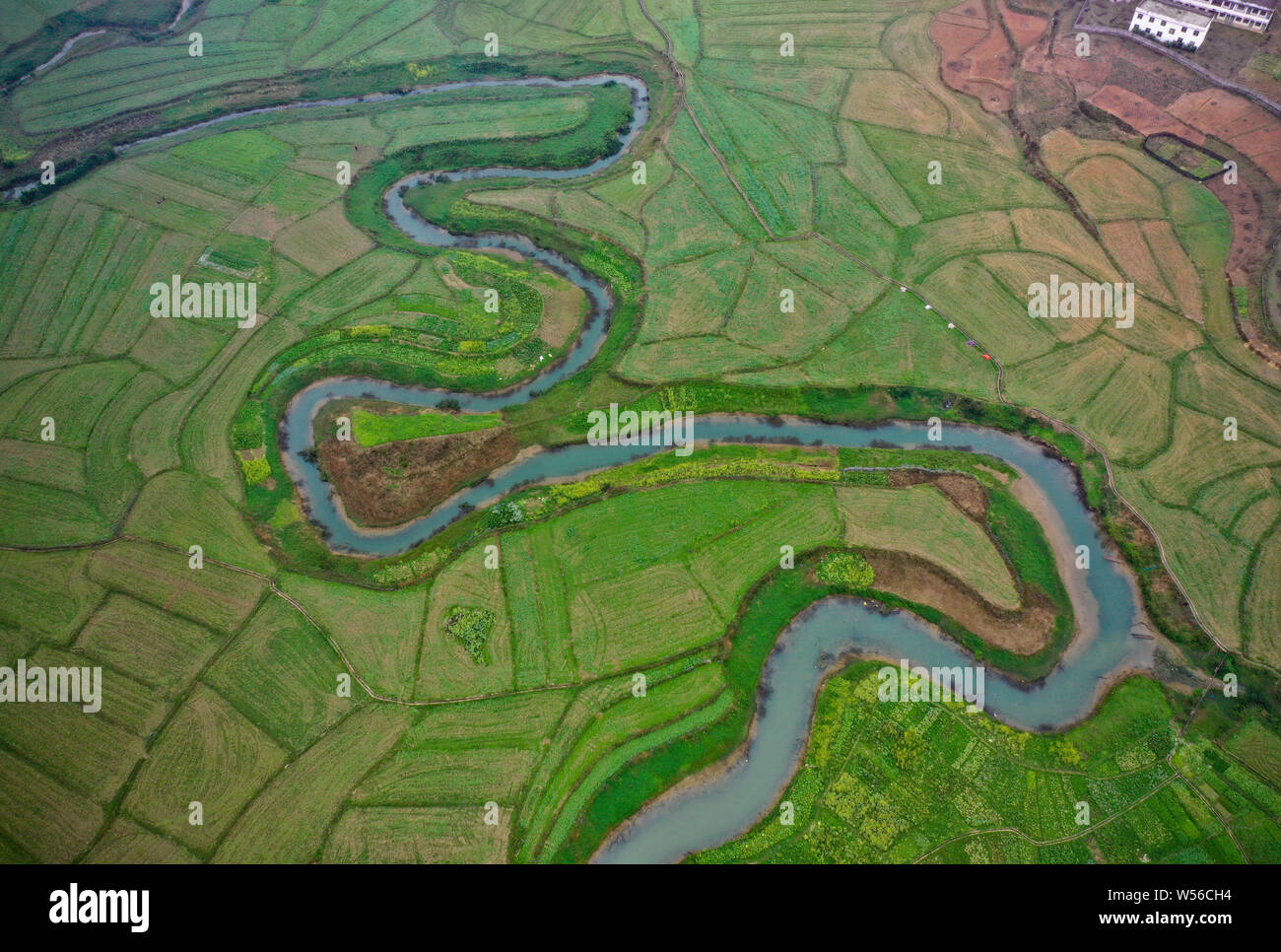 Aerial view of the Ming River, a symbol of Bama, flowing through the fields in Bama Yao ...