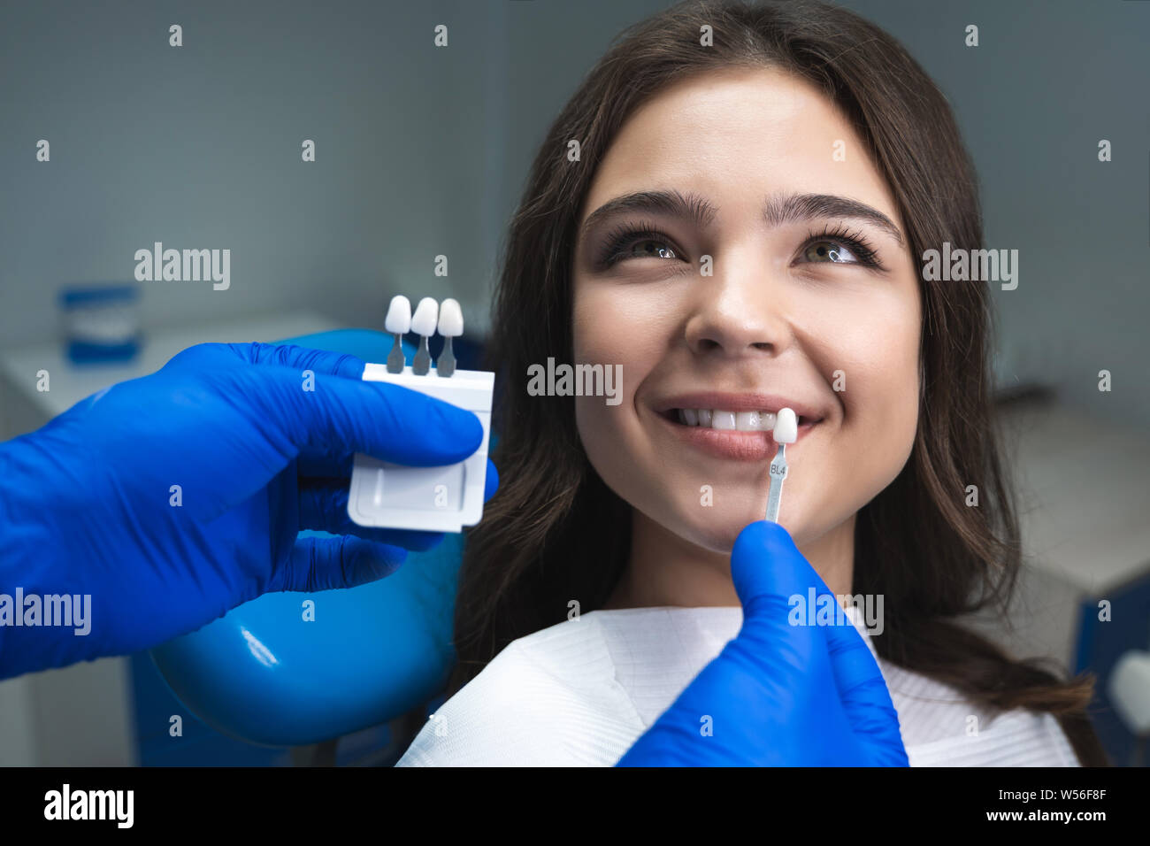 dentist in blue medical gloves applying sample from tooth enamel scale ...