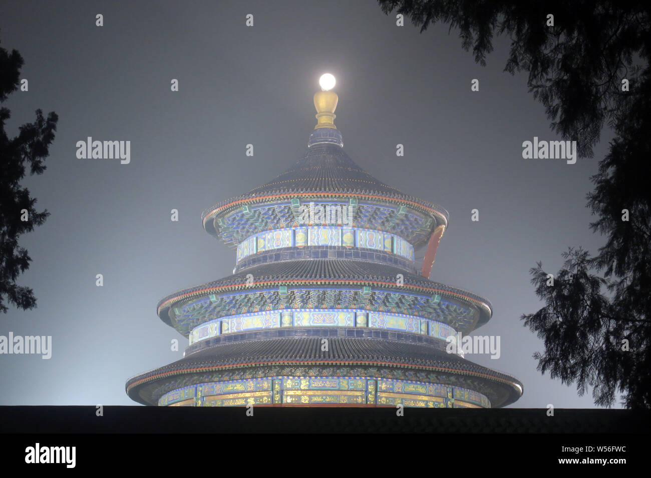 The full moon is seen in the sky over the Hall of Prayer for Good ...