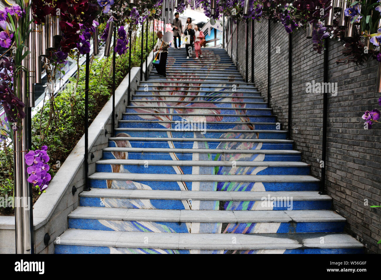 Pedestrians walk on flower painted stairs in Nan'an district, Chongqing ...