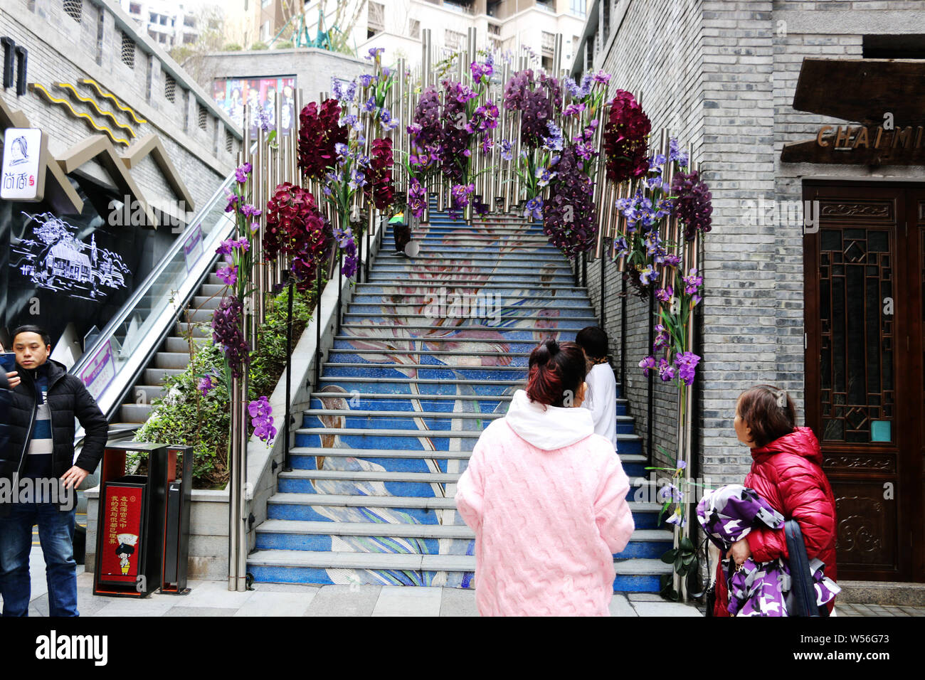 Pedestrians walk on flower painted stairs in Nan'an district, Chongqing ...