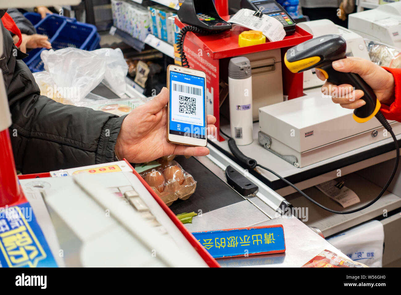 --FILE--A Chinese cashier scans the QR code through mobile payment ...
