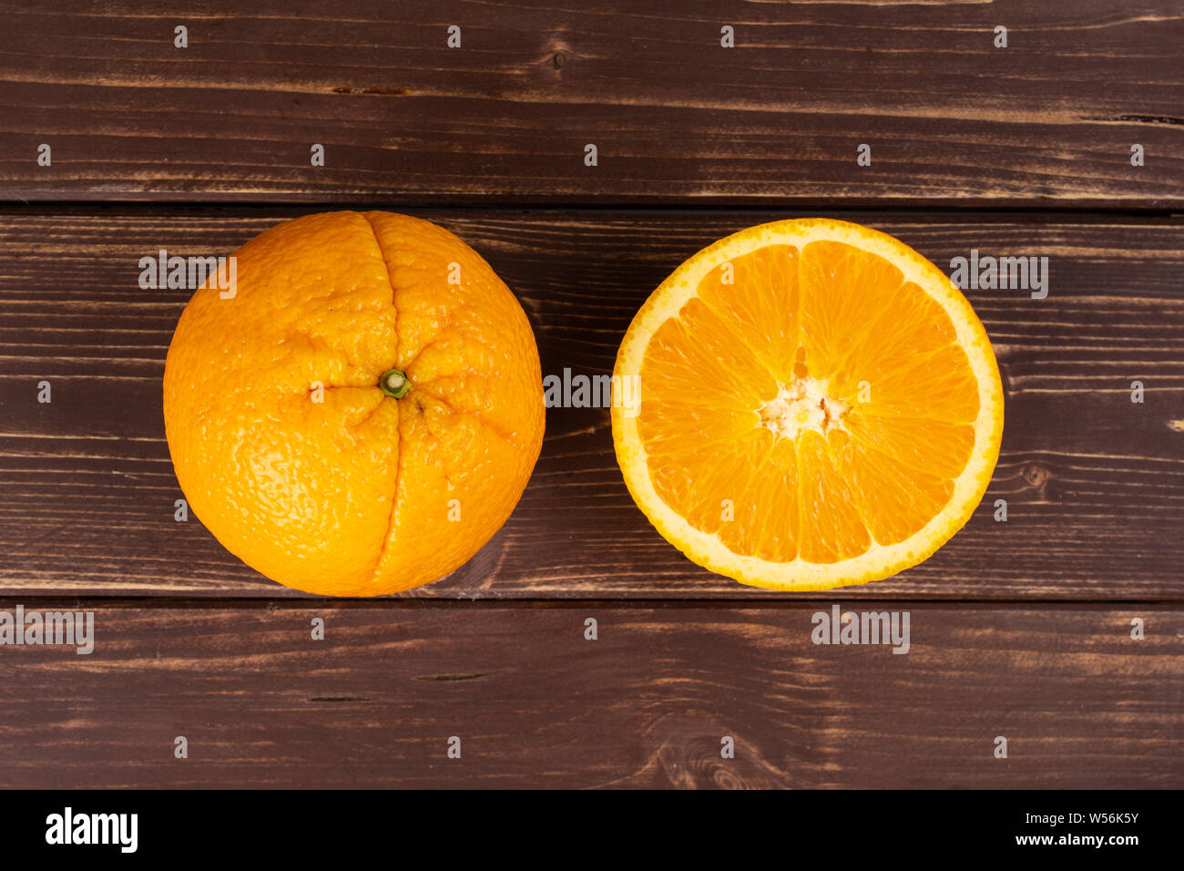 Group of one whole one half of fresh sweet orange flatlay on brown wood ...