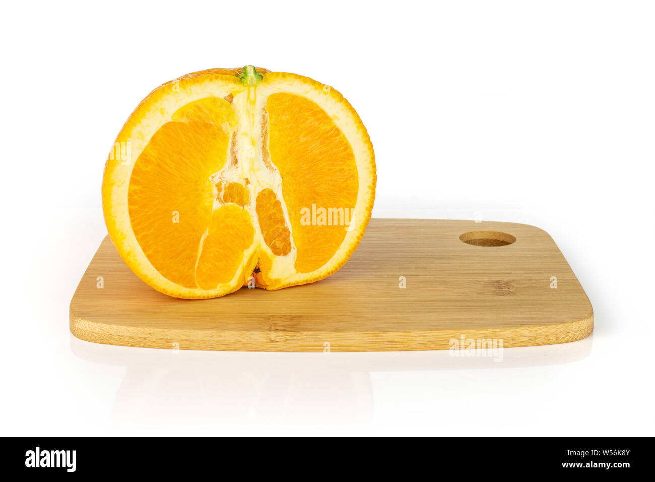 One half of fresh sweet orange on a bamboo cutting board isolated on ...