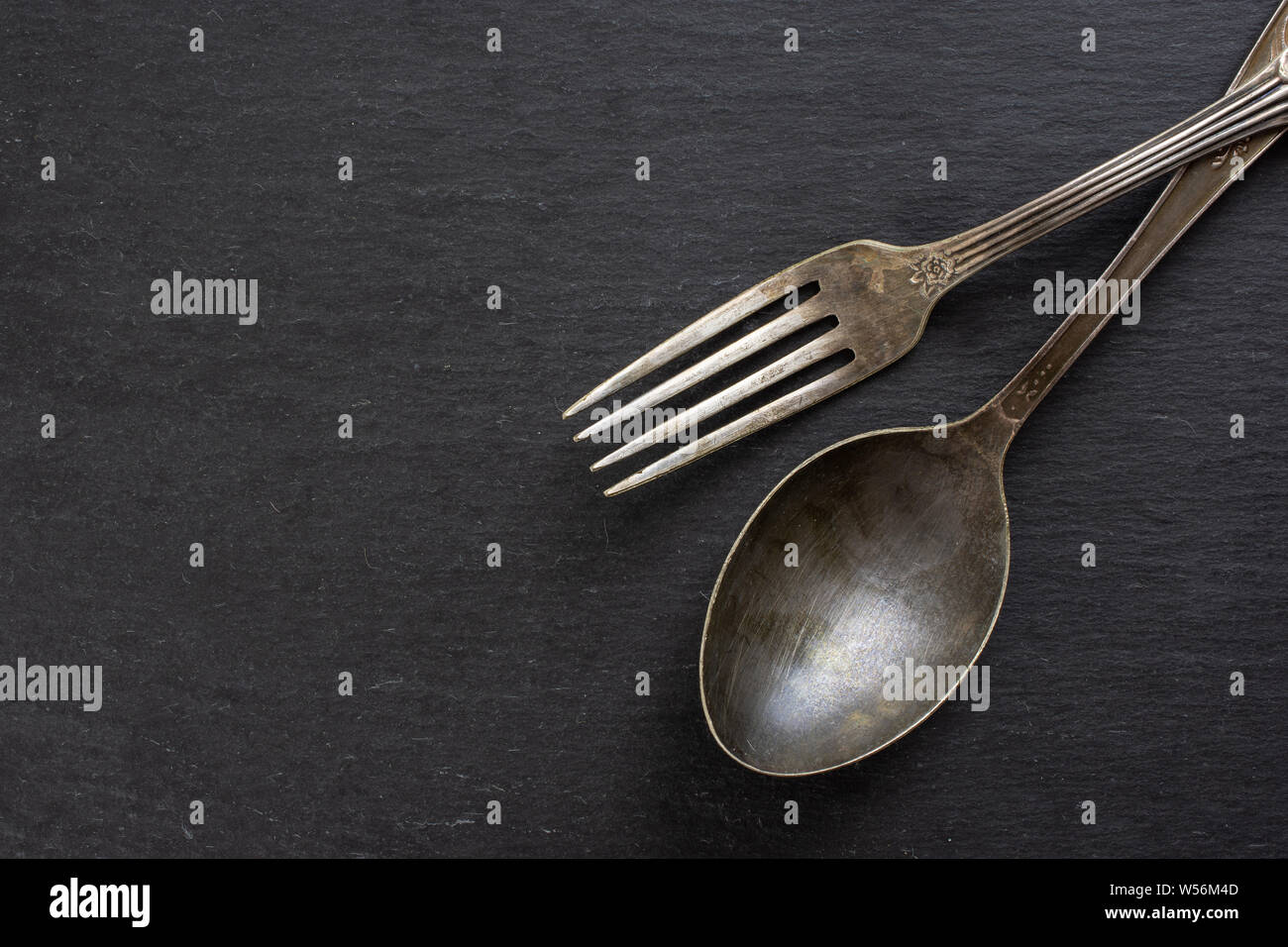 One old rustic iron spoon and a fork with copyspace on left flatlay on ...