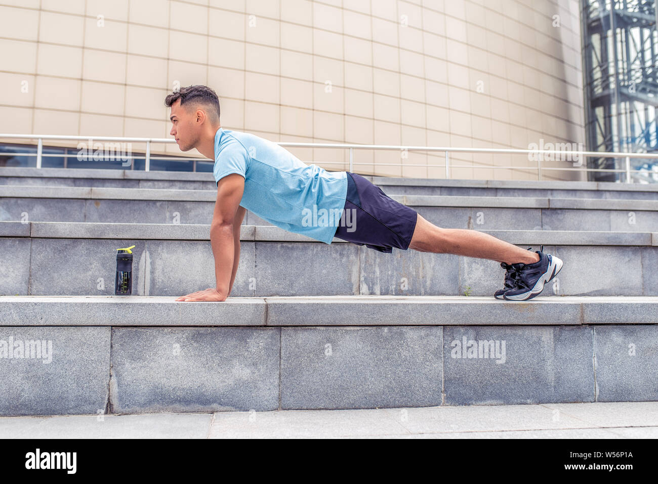 Male athlete, wrung out in summer in city, training muscles of chest ...