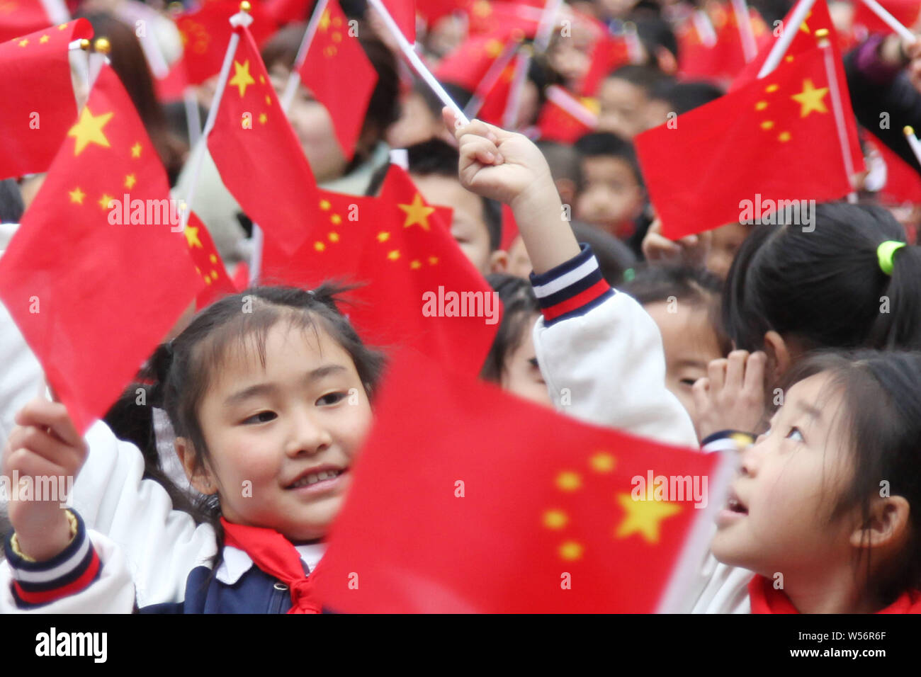 Young Chinese students wave Chinese national flags during the opening ...